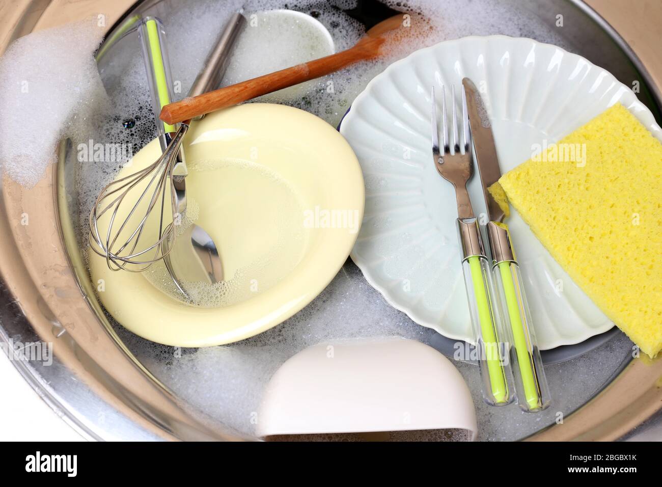 Utensils soaking in kitchen sink Stock Photo - Alamy
