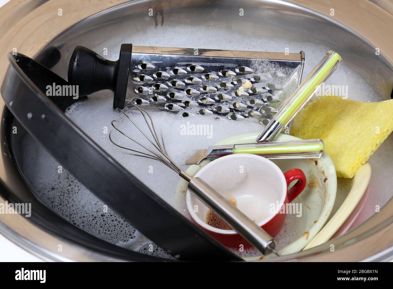 Utensils soaking in kitchen sink Stock Photo - Alamy