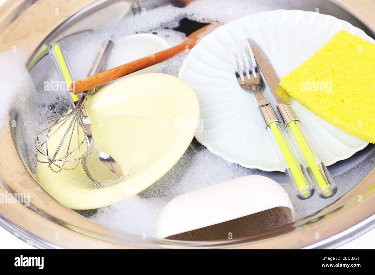 Utensils soaking in kitchen sink Stock Photo - Alamy