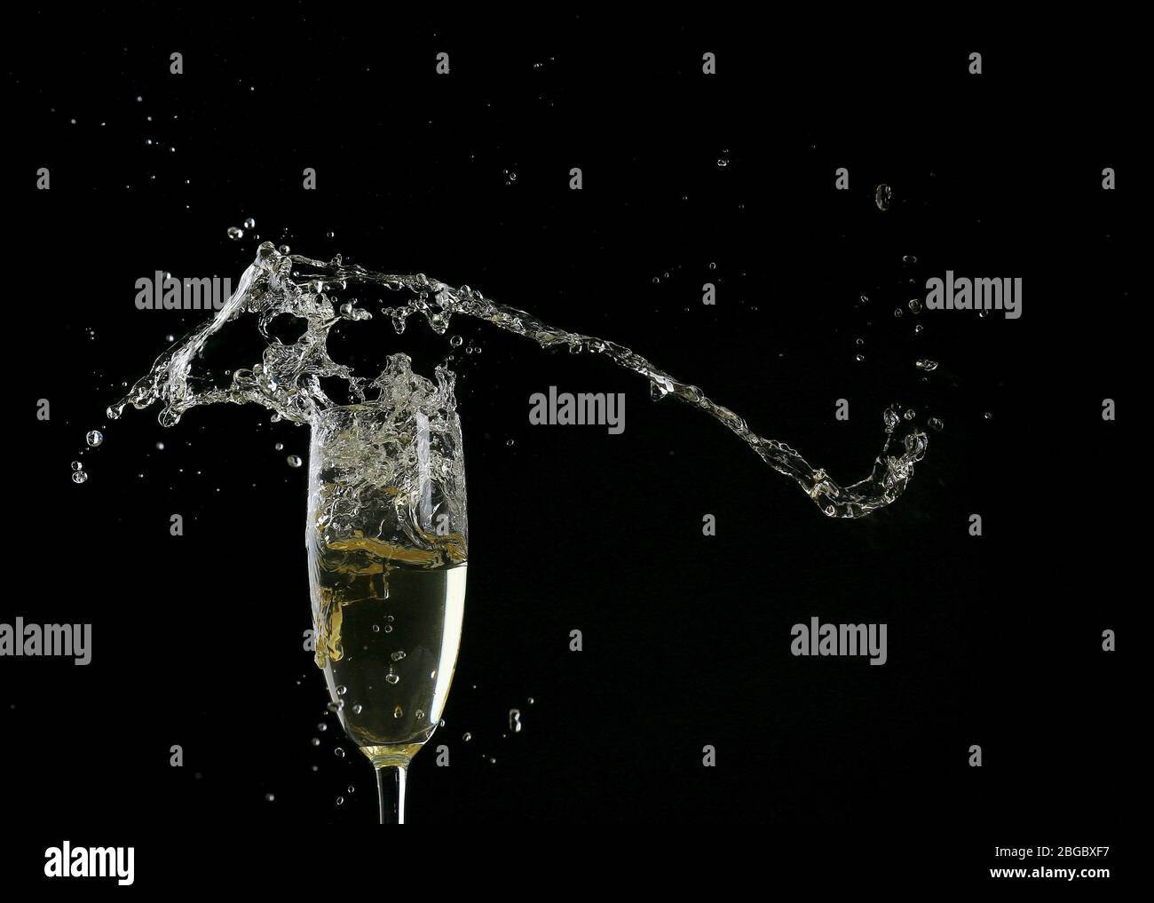 Glass of champagne with splash, on black background Stock Photo - Alamy