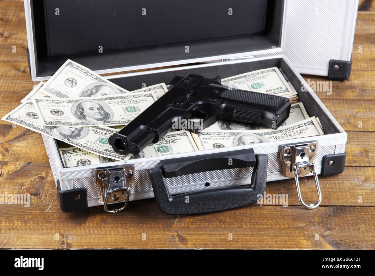 Case with money and gun, on wooden background Stock Photo - Alamy