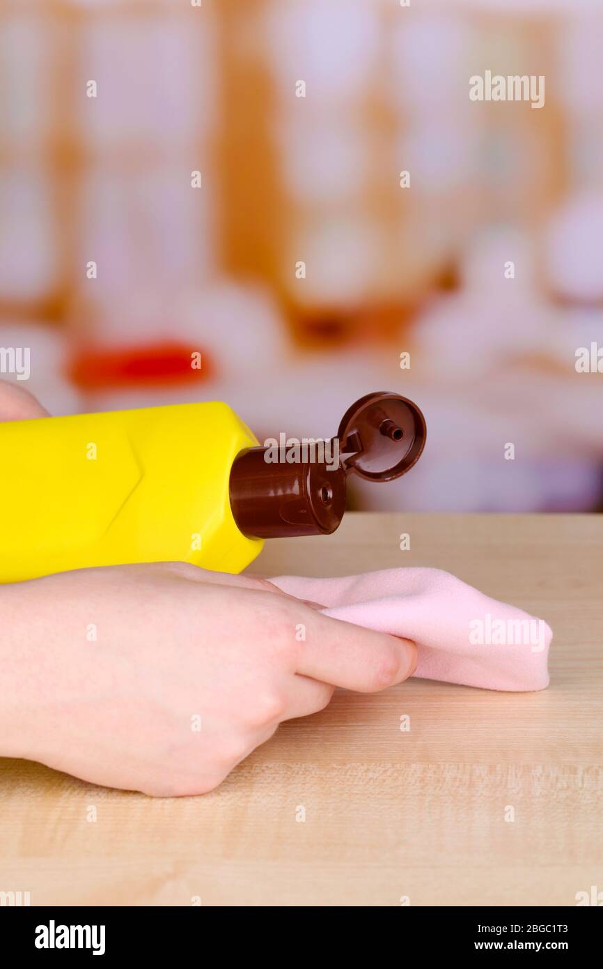 Hand cleaning wooden table with furniture polish Stock Photo - Alamy