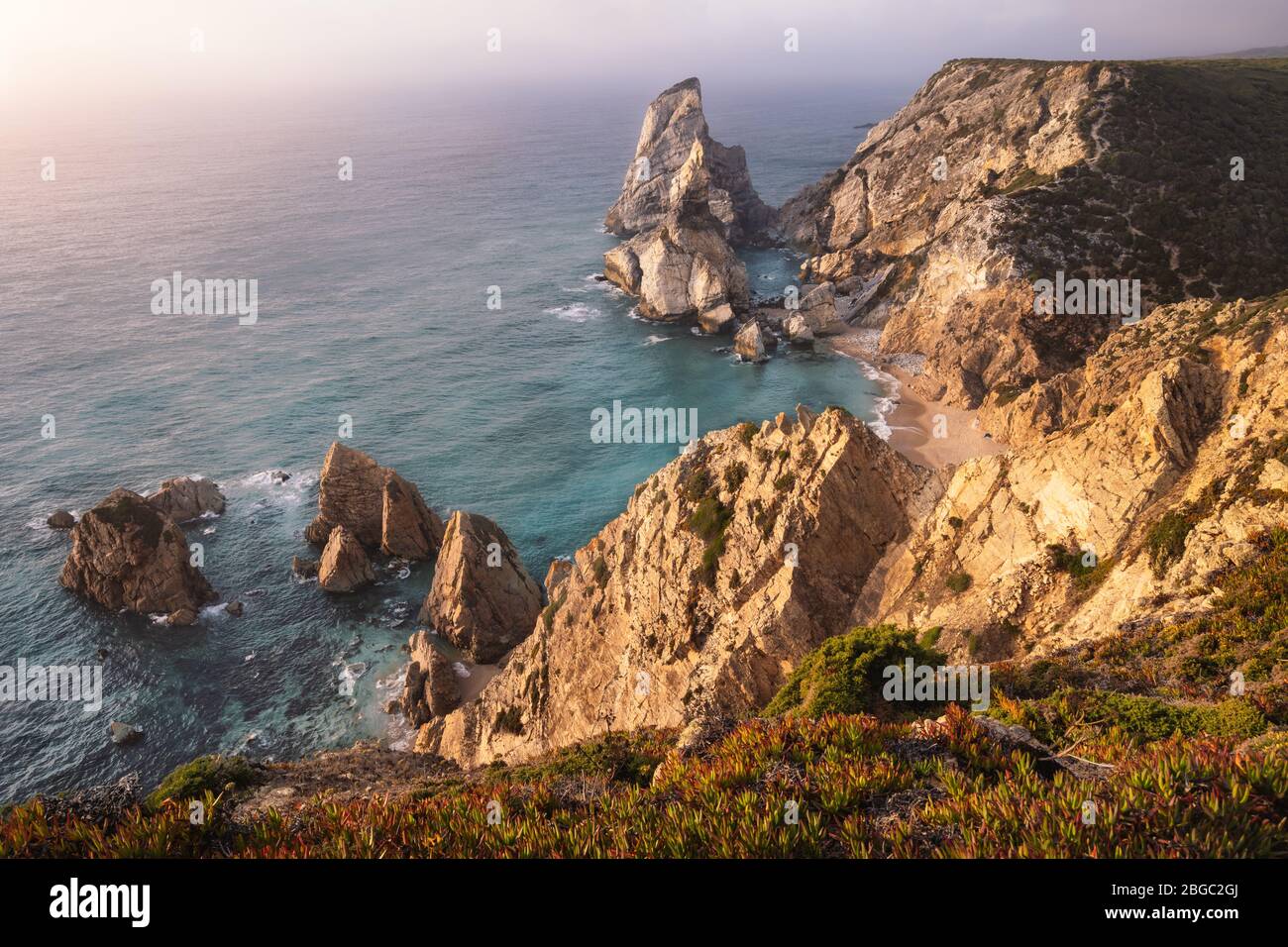 Sunset at Praia da Ursa Beach. Rocky cliff ridge with sea stack in ...