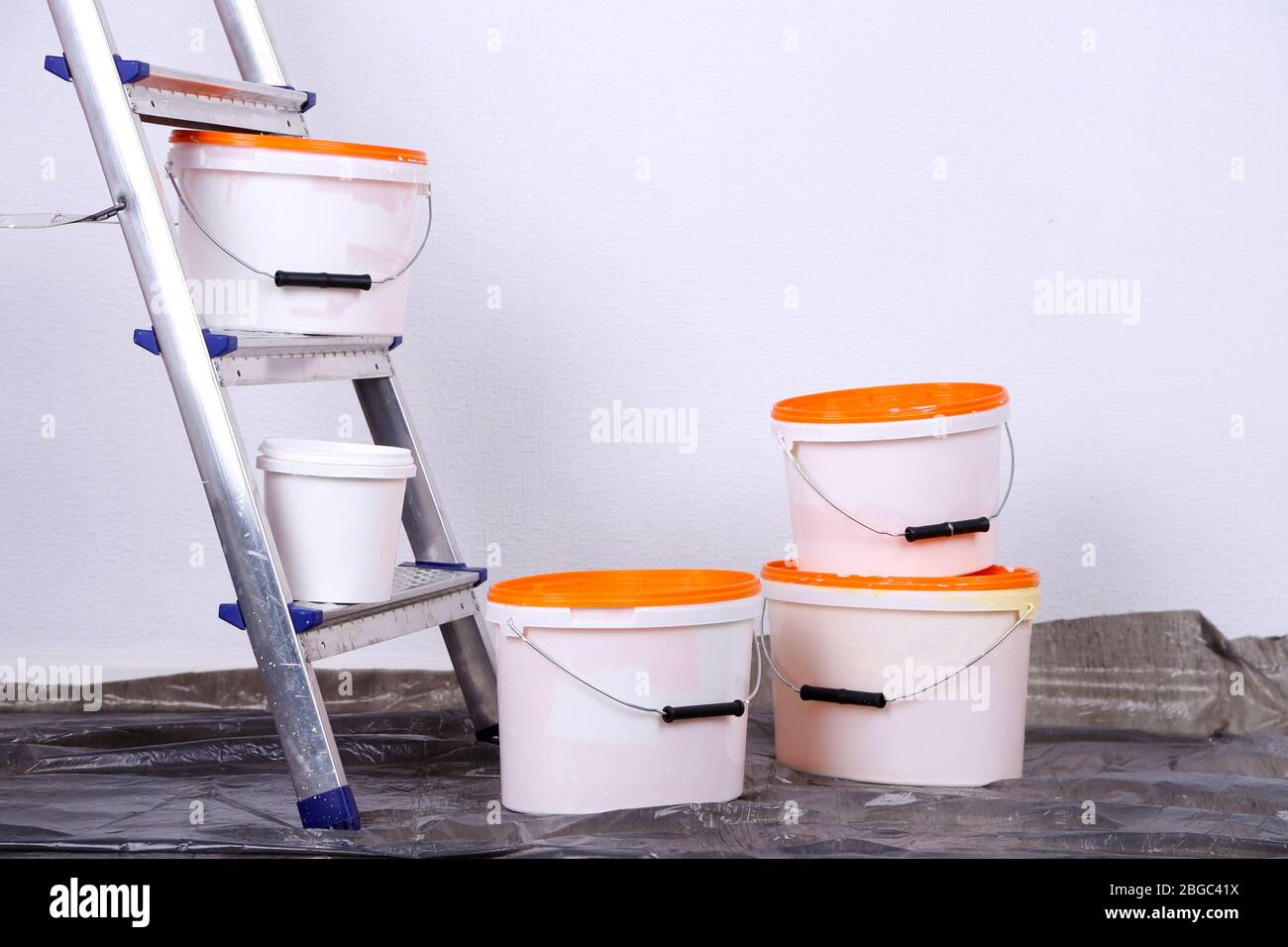 Buckets with paint and ladder on wall background. Conceptual photo of ...