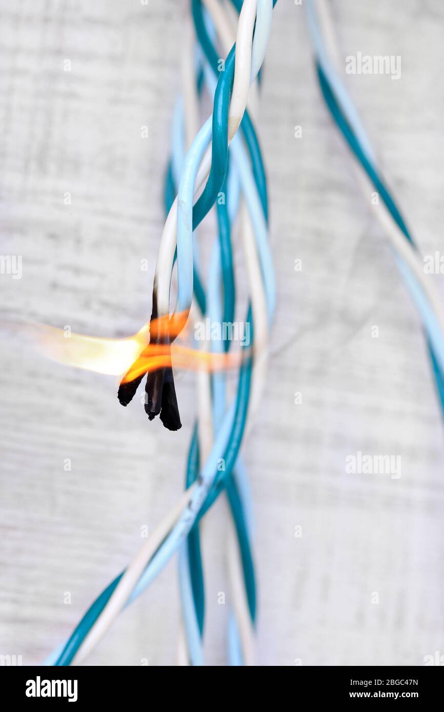 Short circuit, burnt cable, on color wooden background Stock Photo - Alamy
