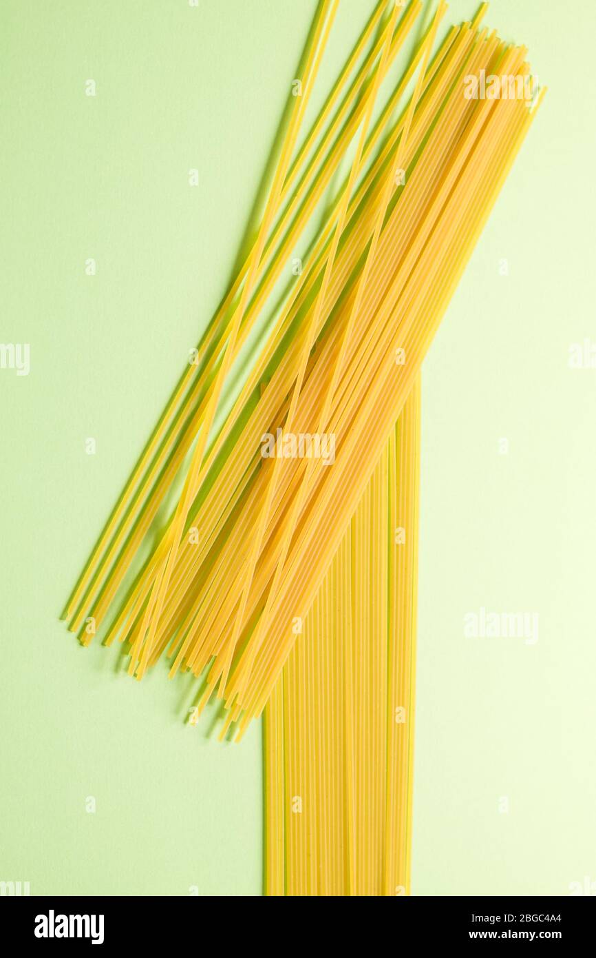 Creative composition, two bouquets of raw spaghetti resting on a green ...