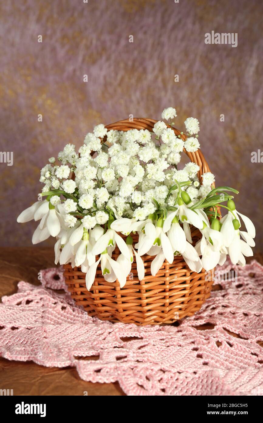 Beautiful snowdrops in basket, on brown background Stock Photo - Alamy