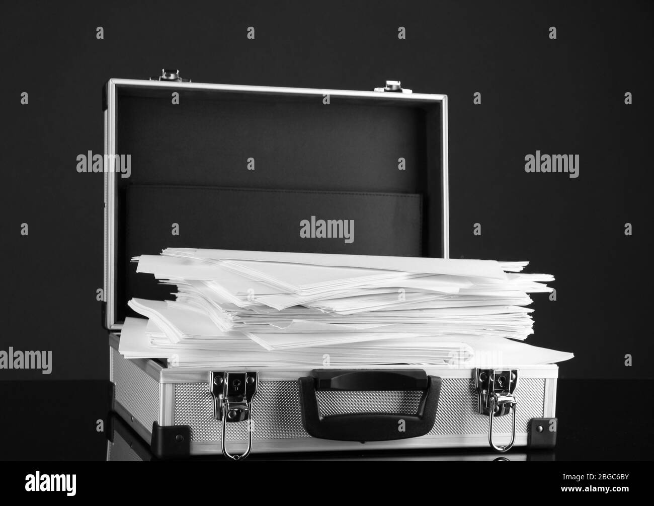 Briefcase full of papers, isolated on black Stock Photo - Alamy