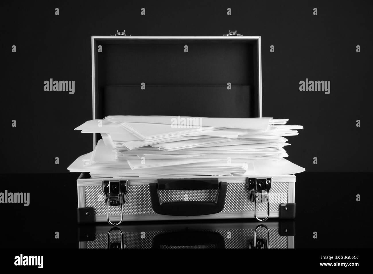 Briefcase full of papers, isolated on black Stock Photo - Alamy