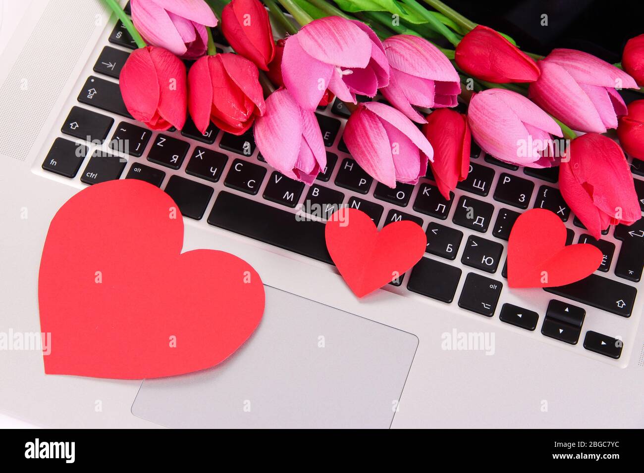 Red hearts and flowers on computer keyboard close up Stock Photo - Alamy