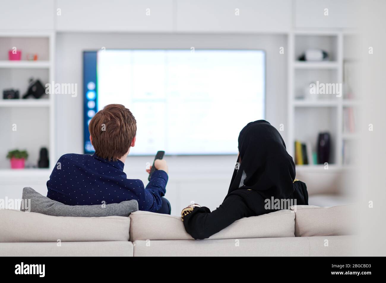 young muslim couple woman wearing islamic hijab clothes sitting on sofa ...