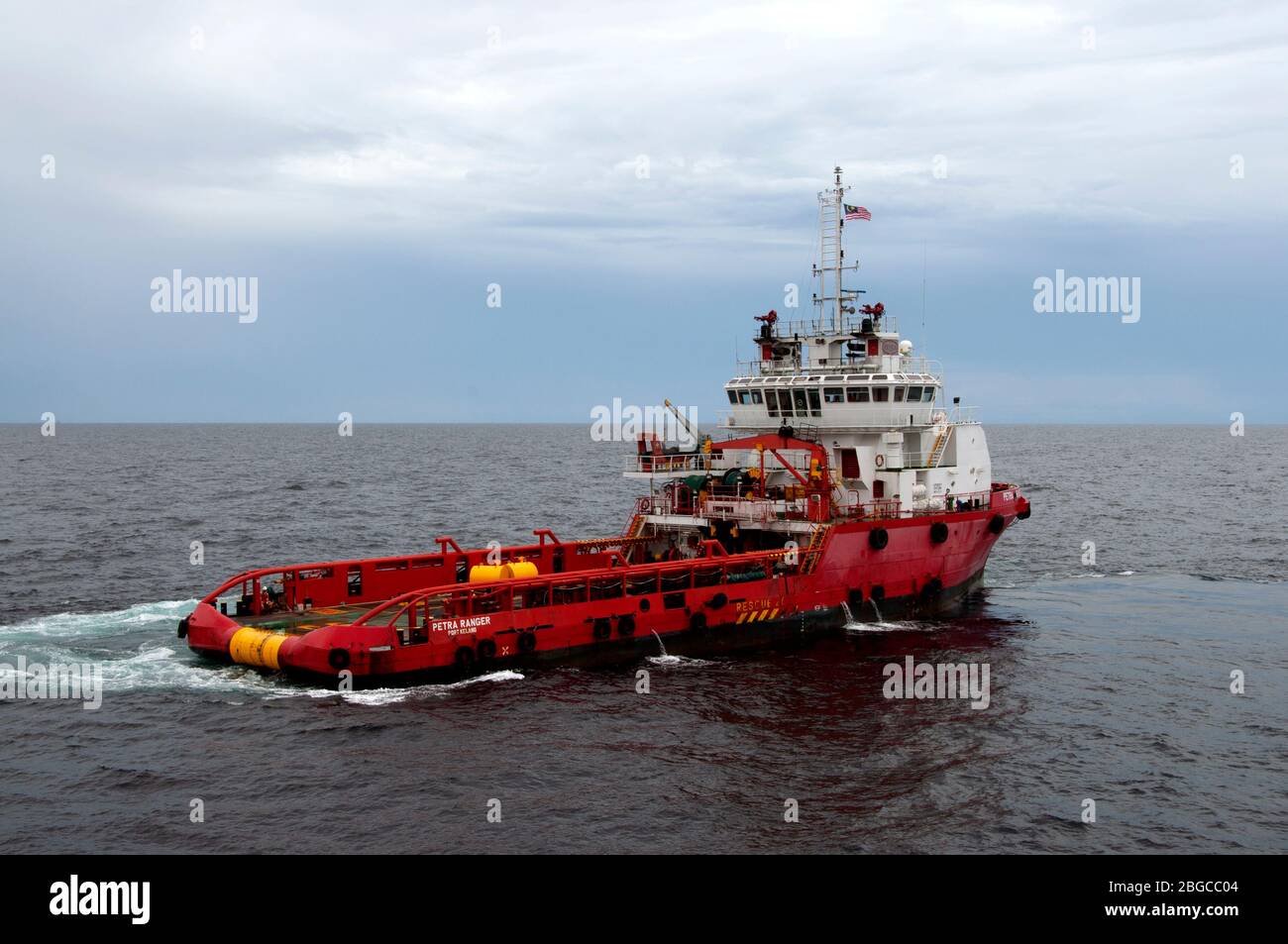 offshore supply vessel steaming around oil platform at sea during day ...