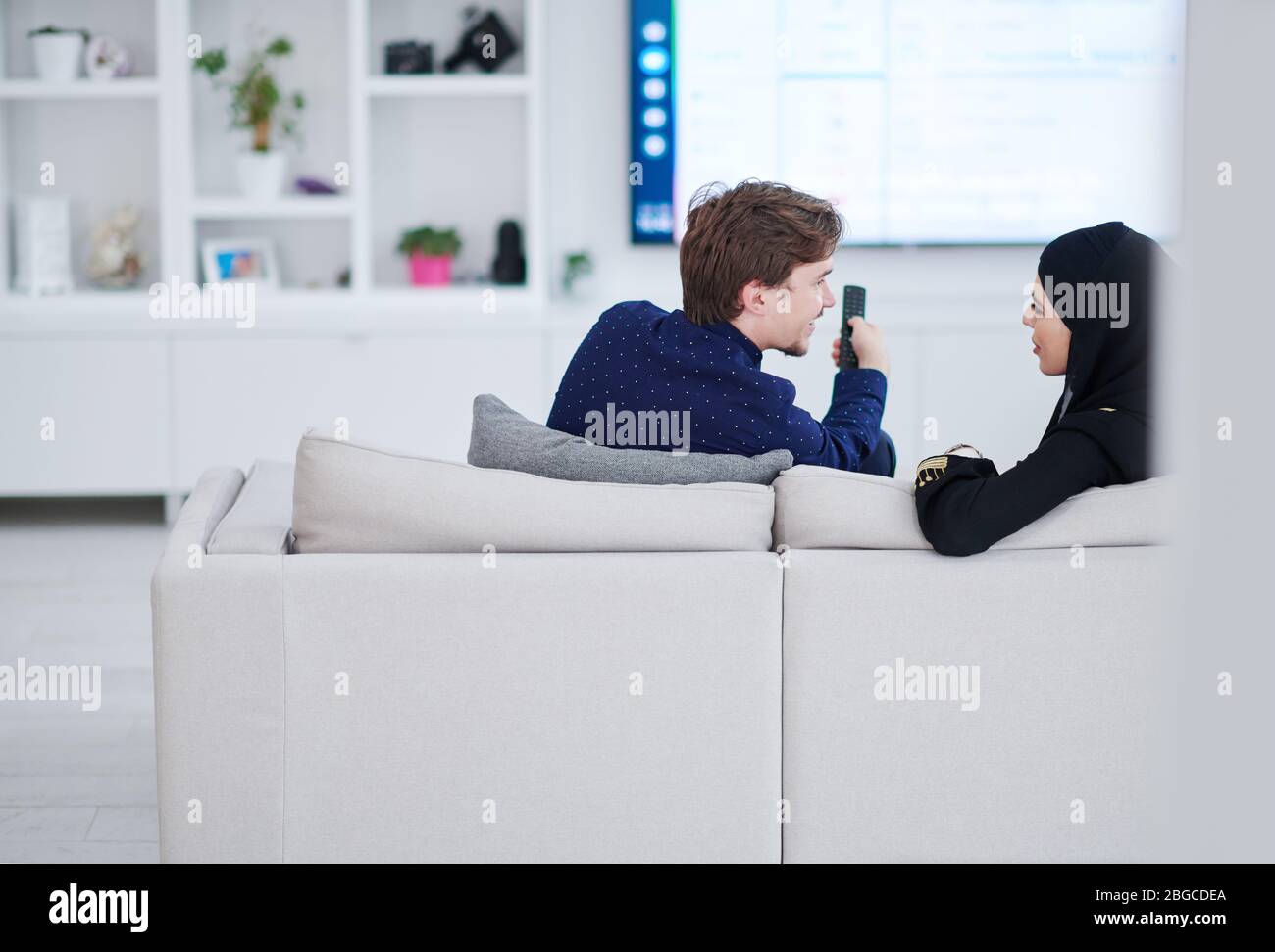 young muslim couple woman wearing islamic hijab clothes sitting on sofa ...