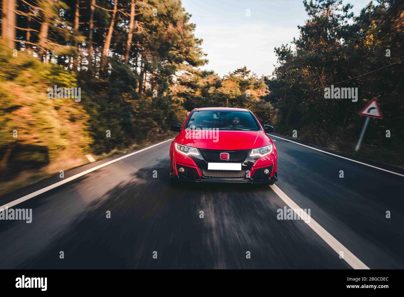 Red chasing car on the mountain road across trees Stock Photo - Alamy