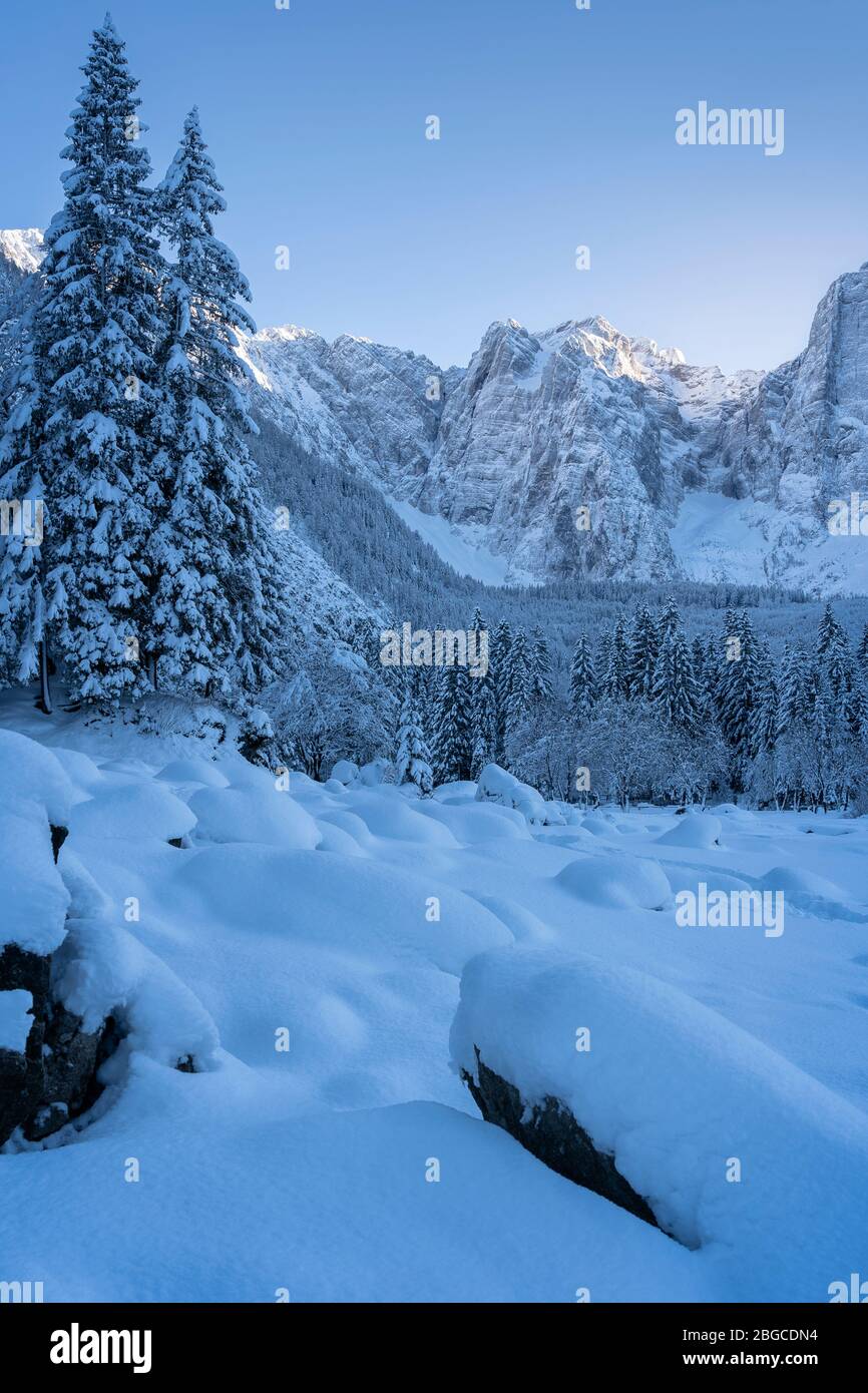 Winter sunset over the upper lake of Fusine with fresh snow and alpine ...