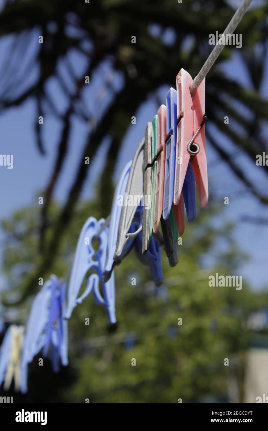 row of plastic pegs on clothes line Stock Photo - Alamy