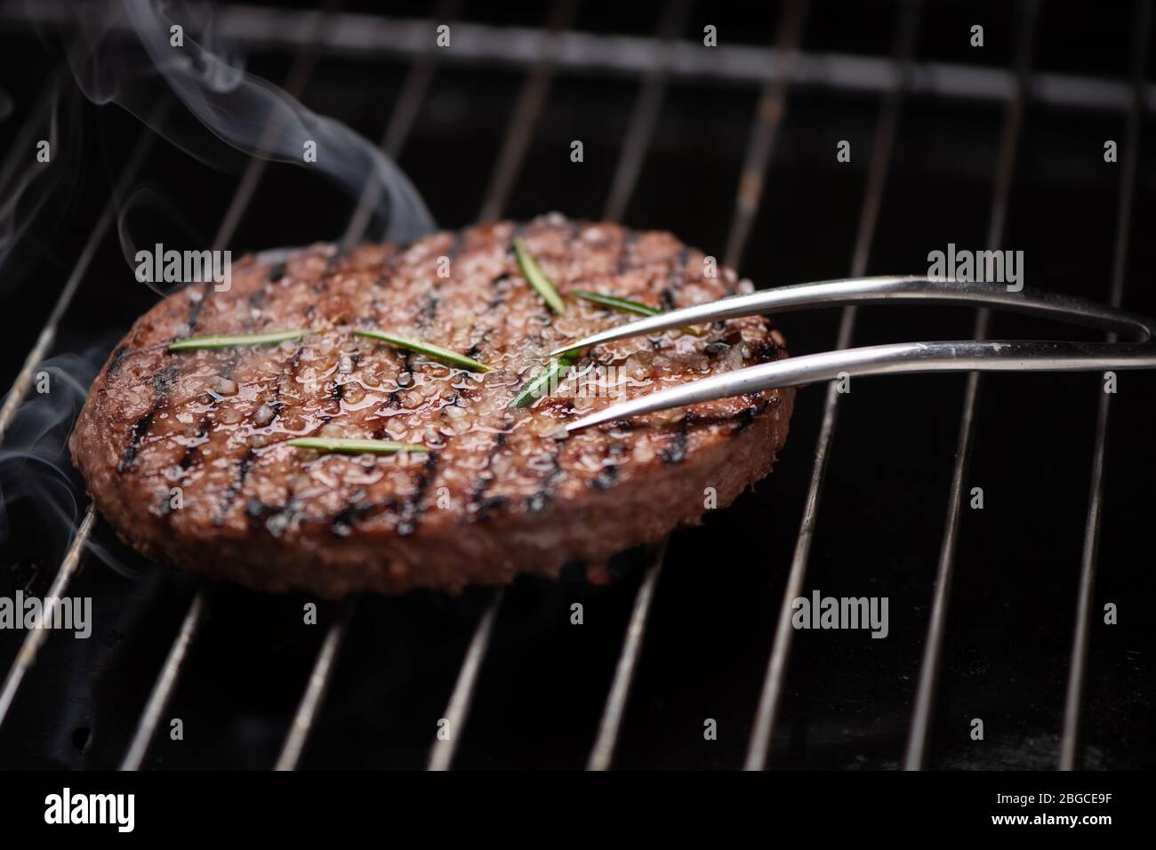 A beef burger grill cooking close up Stock Photo - Alamy