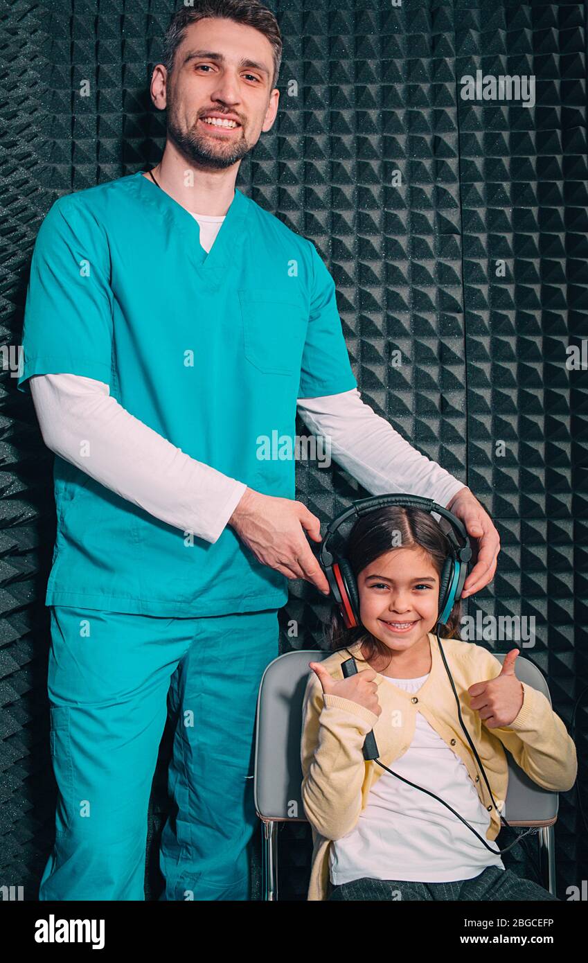 audiometry test. Audiologist doing hearing test to a little girl ...