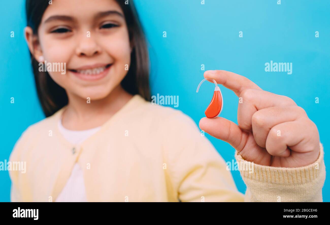 advertising hearing aid for children, a mixed race child shows a ...