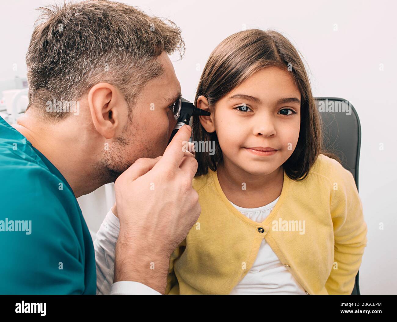 Ear exam. Pediatrician examining little mixed race child with otoscope ...