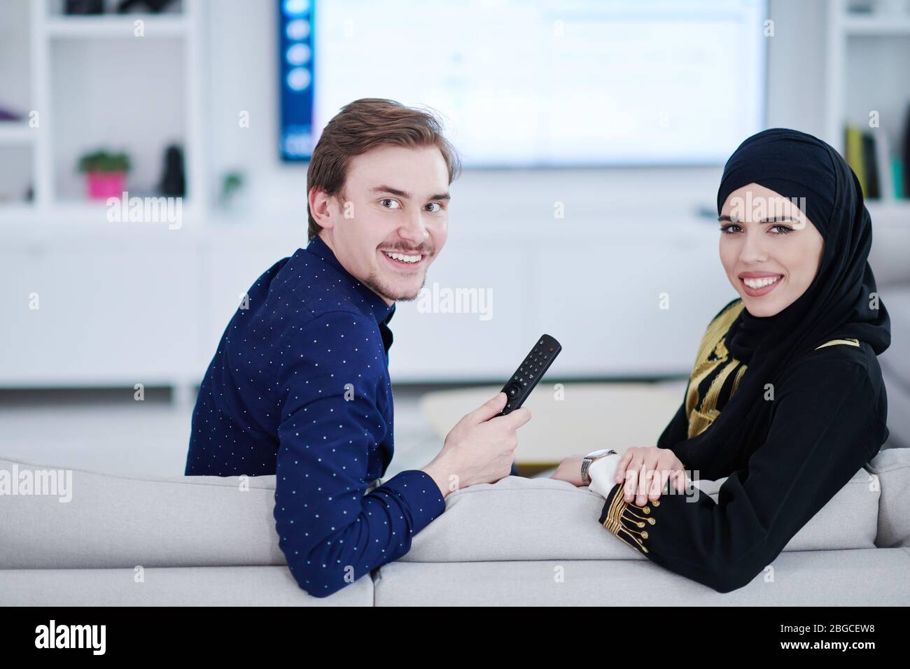 young muslim couple woman wearing islamic hijab clothes sitting on sofa ...