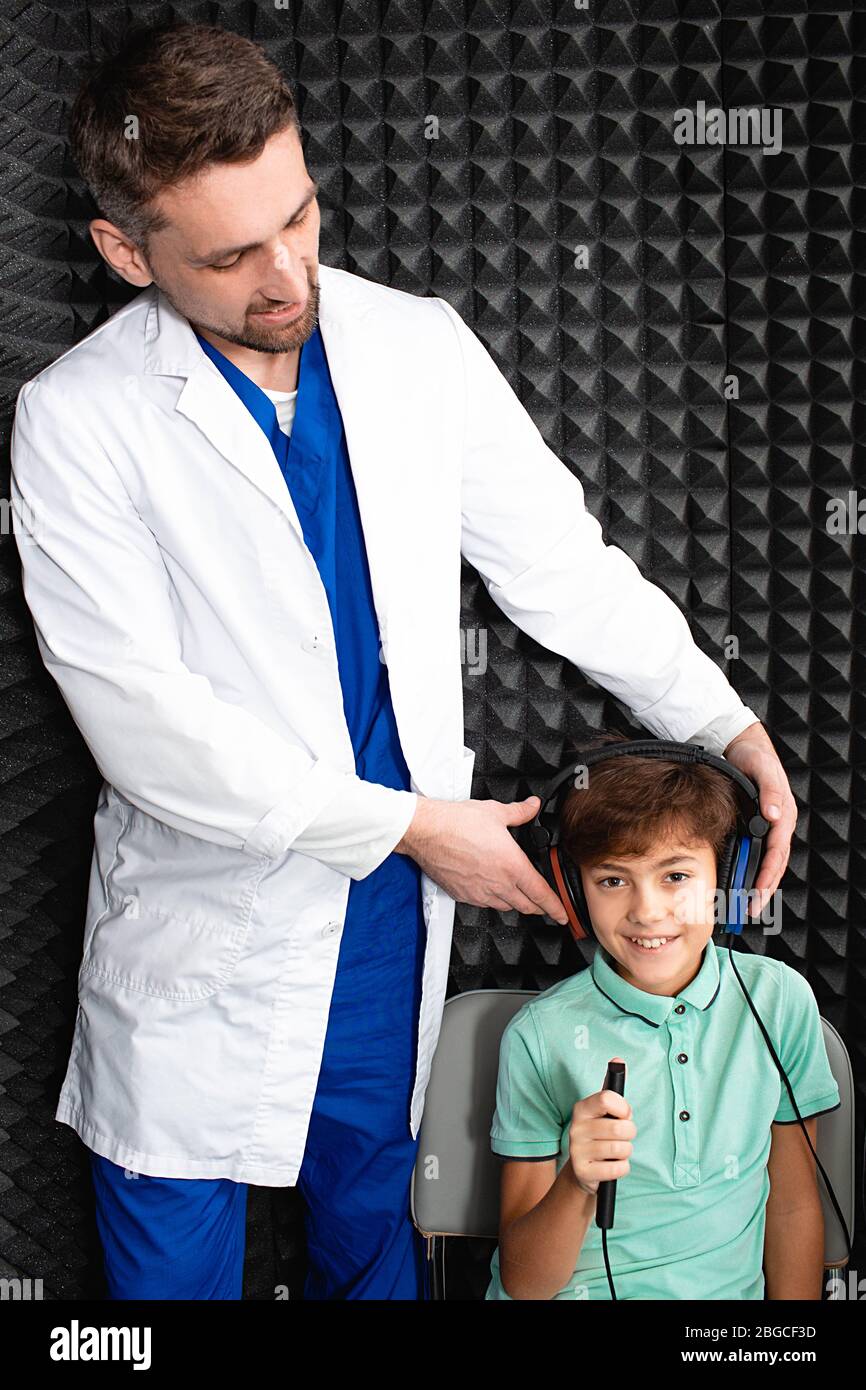 Little boy having hearing test. He setting at soundproof cabin, boy ...