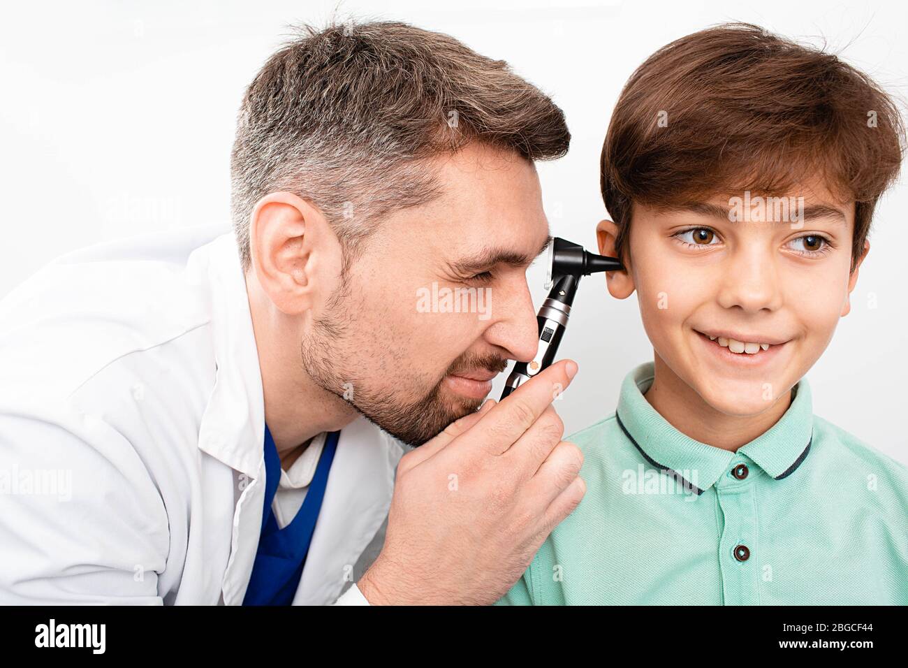 Audiologist checks the boy's hearing with an ophthalmoscope. Hearing ...