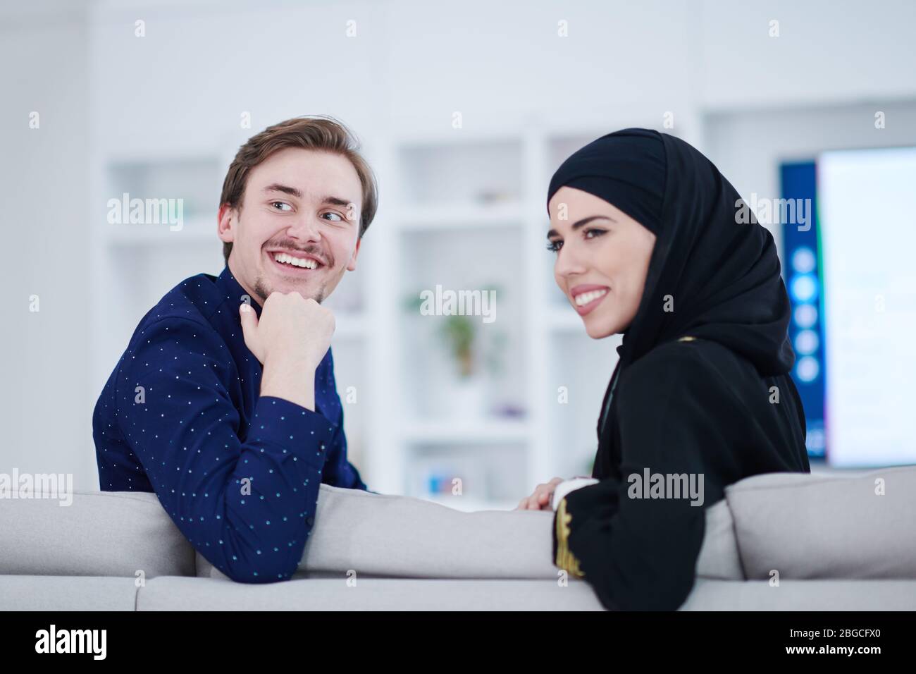 young muslim couple woman wearing islamic hijab clothes sitting on sofa ...