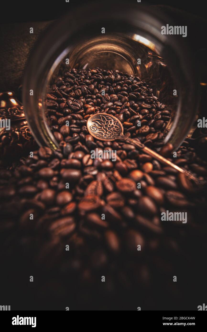 Coffee beans spilled out of a glass jar, dark background Stock Photo ...
