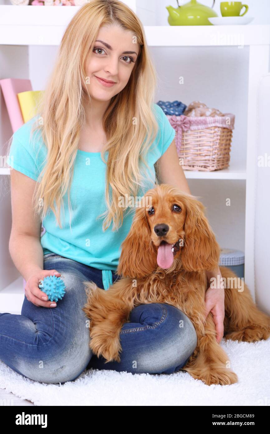 Beautiful young woman with cocker spaniel in room Stock Photo - Alamy