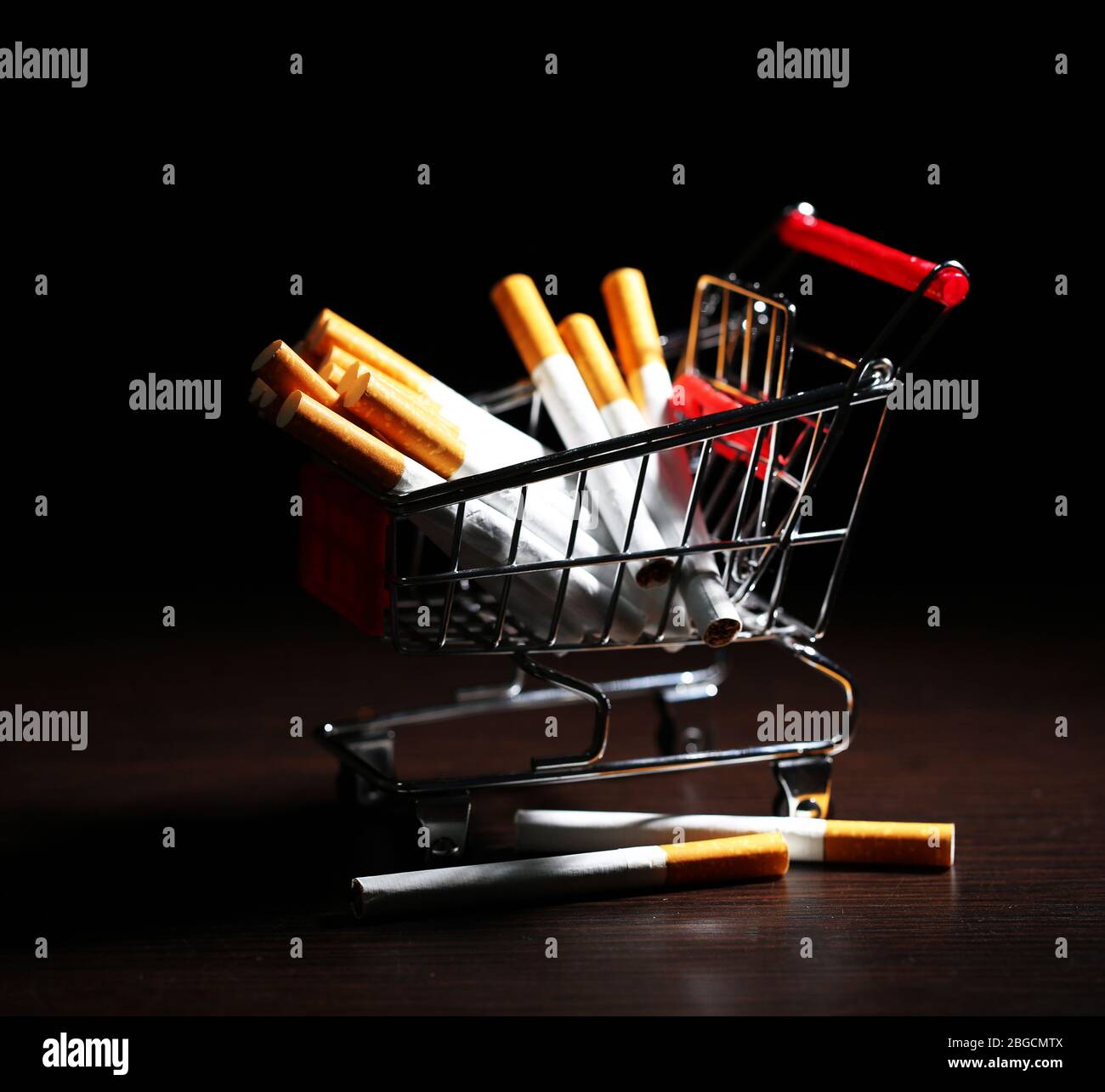Cigarettes in shopping cart on wooden table on dark background Stock ...