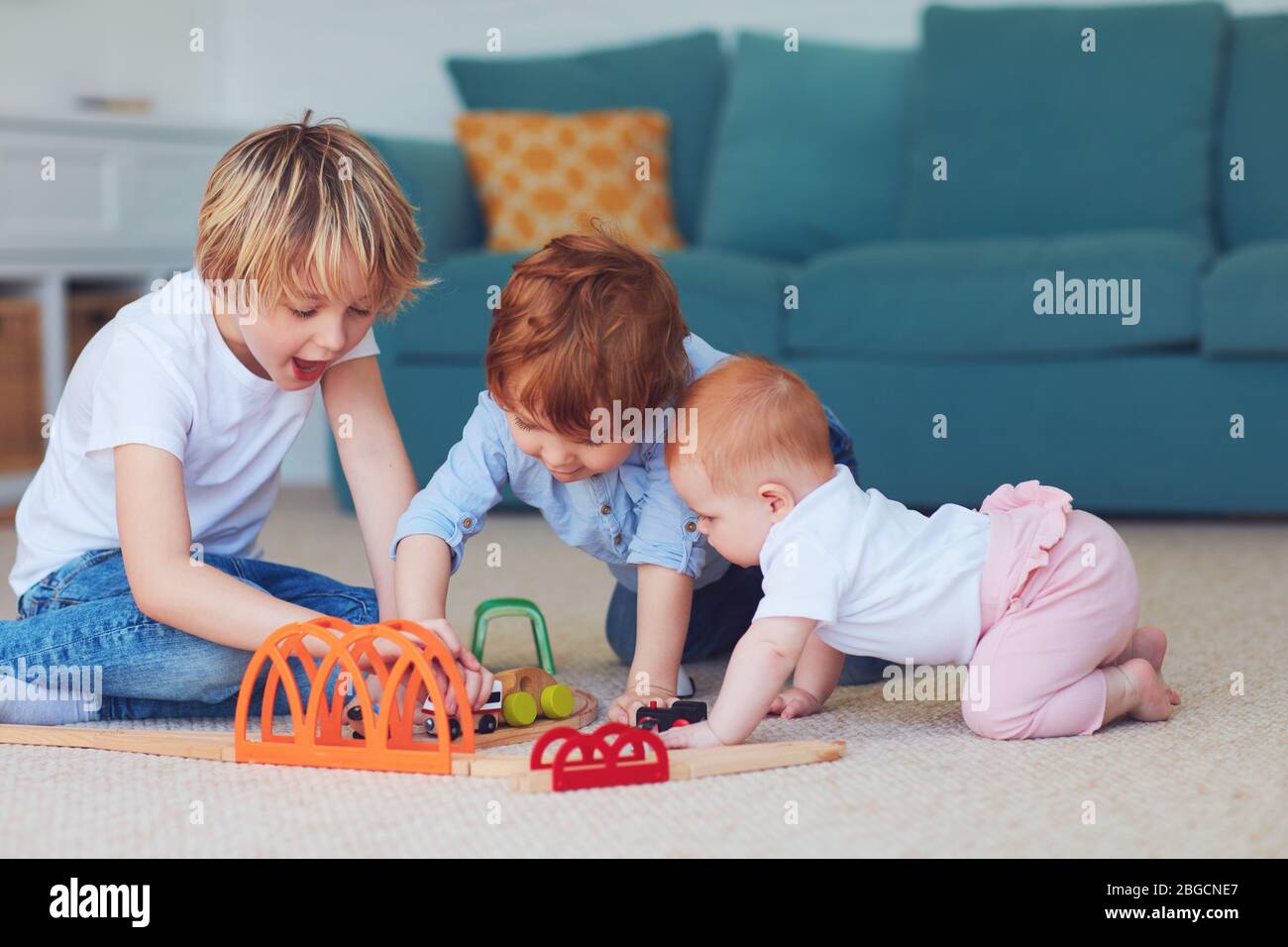 cute kids, siblings playing toys together on the carpet at home Stock ...