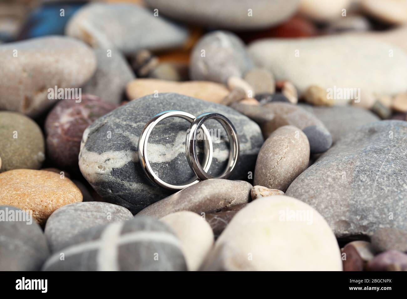 Wedding rings on rocks close-up Stock Photo - Alamy