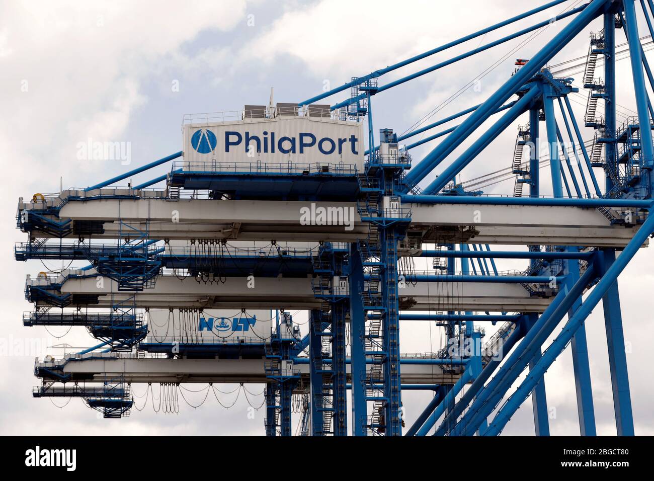 A row of massive cranes sit ready to offload incoming cargo ships at ...