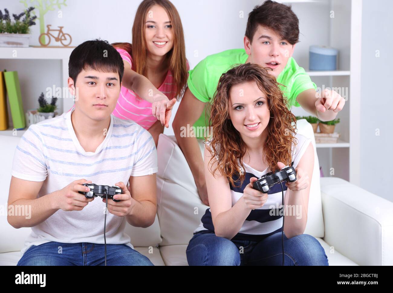 Group of young friends playing video games at home Stock Photo - Alamy