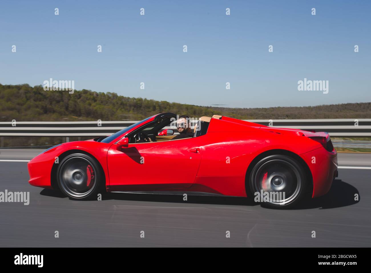 Red sport car driving on the freeway in a sunny day,profile view Stock ...