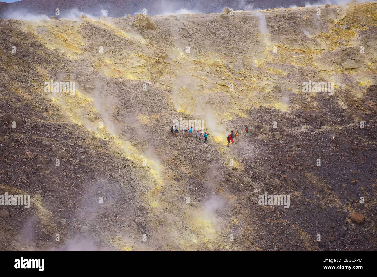 Group of tourists walking through fumarole smoke at Gran Cratere ...