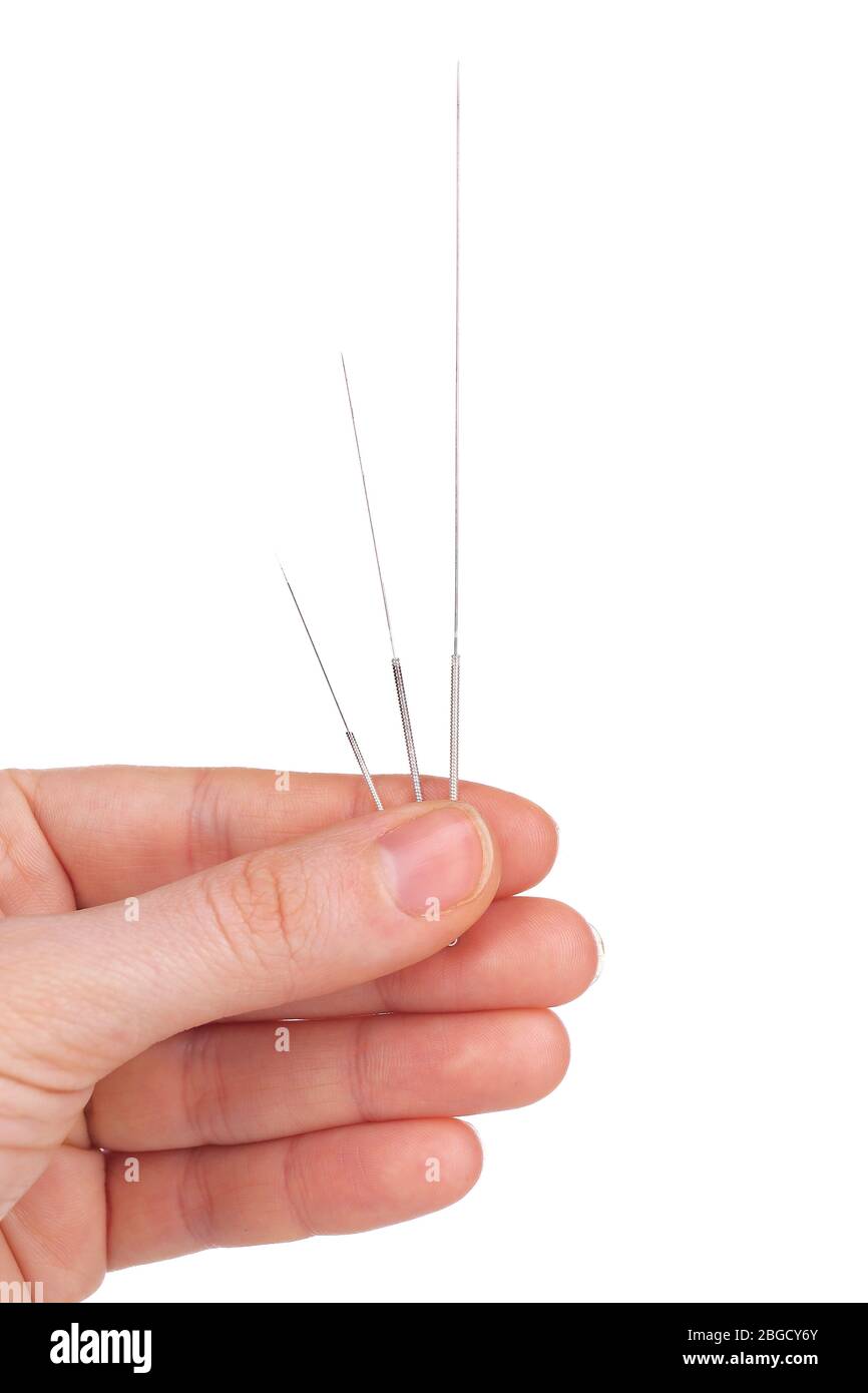 Hand holding needles for acupuncture on hand, close up. Isolated on ...
