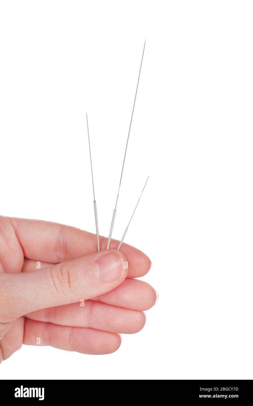 Hand holding needles for acupuncture on hand, close up. Isolated on ...