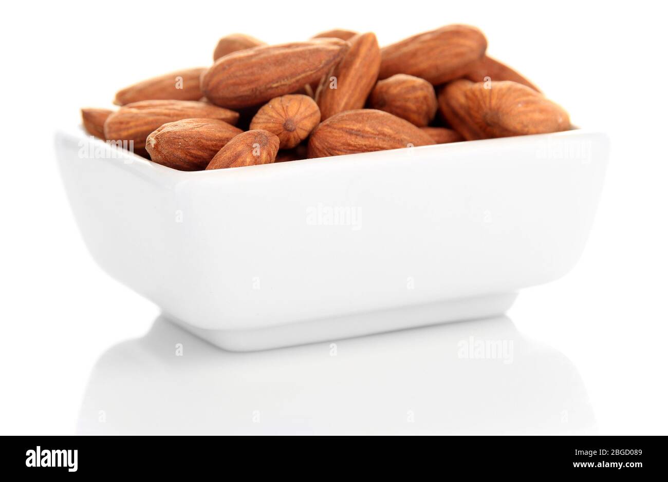 Almond in bowl, isolated on white Stock Photo - Alamy