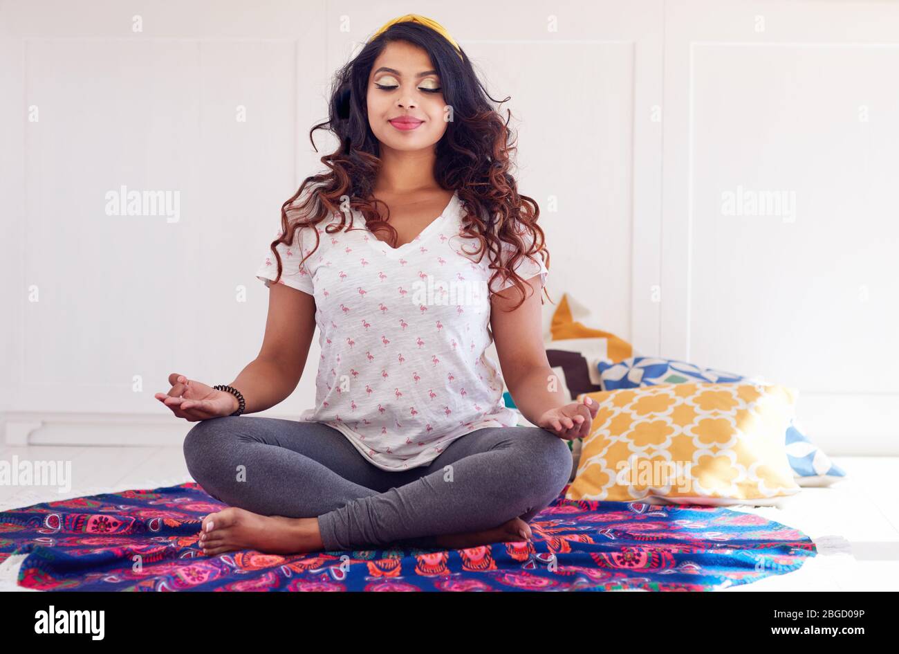 beautiful indian woman, doing yoga exercises at home, Padmasana or ...