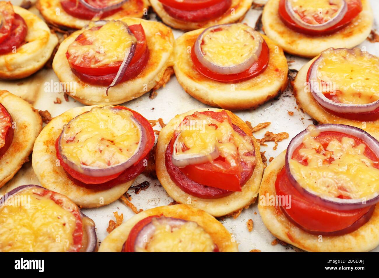 Small pizzas on baking paper close up Stock Photo - Alamy