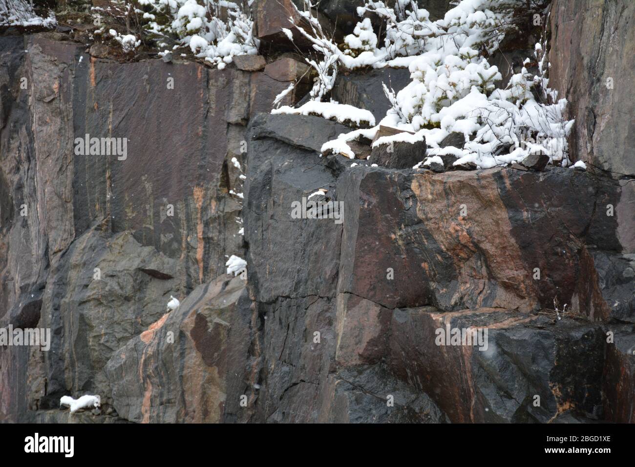 Fresh white snow on dark granite rock Stock Photo - Alamy