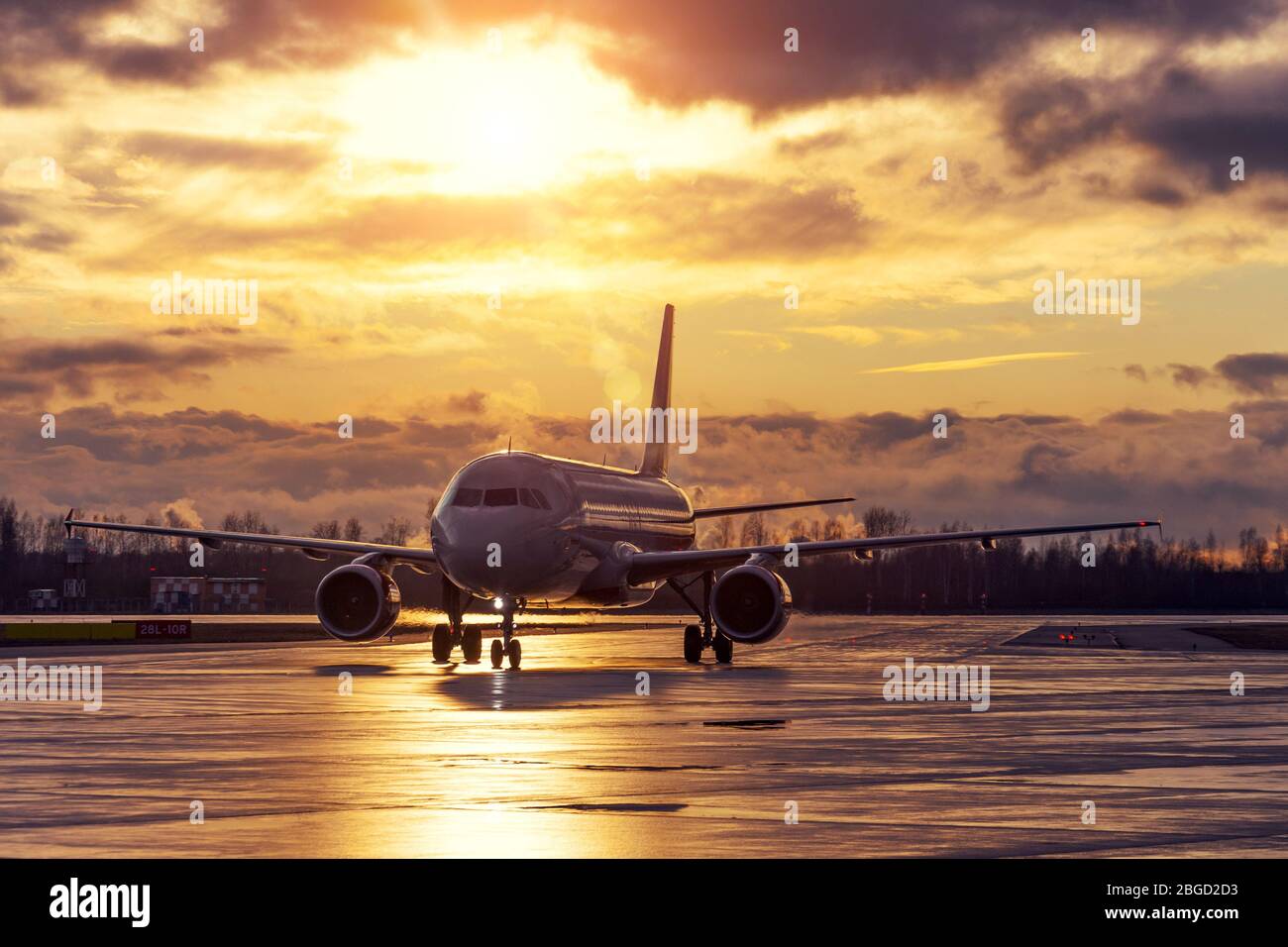 Passenger aircraft taxiing after landing on wet runway in rainy weather ...