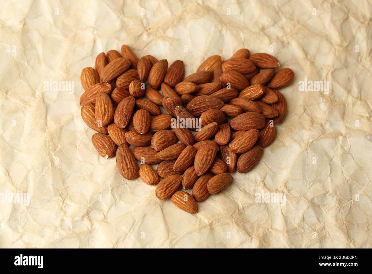 Almonds on old paper background Stock Photo - Alamy