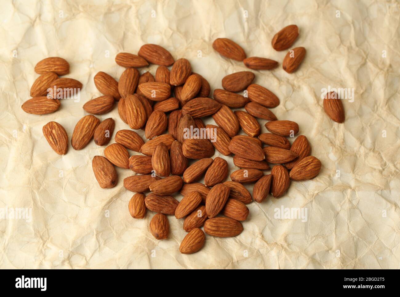 Almonds on old paper background Stock Photo - Alamy