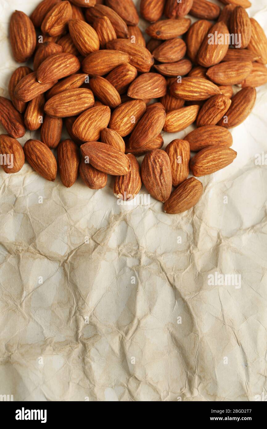 Almonds on old paper background Stock Photo - Alamy