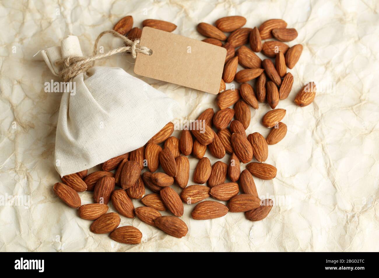 Almonds on old paper background Stock Photo - Alamy