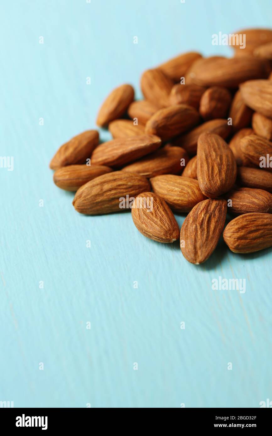 Almonds on color wooden background Stock Photo - Alamy