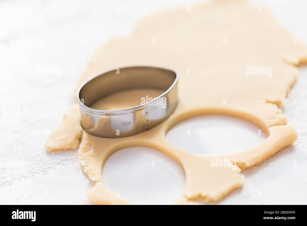 Cutting out shapes with metal cookie cutter out of the sugar cookie ...